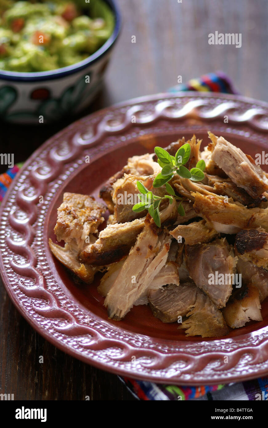 mexican traditional carnitas (braised pork) on a copper plate with a ...