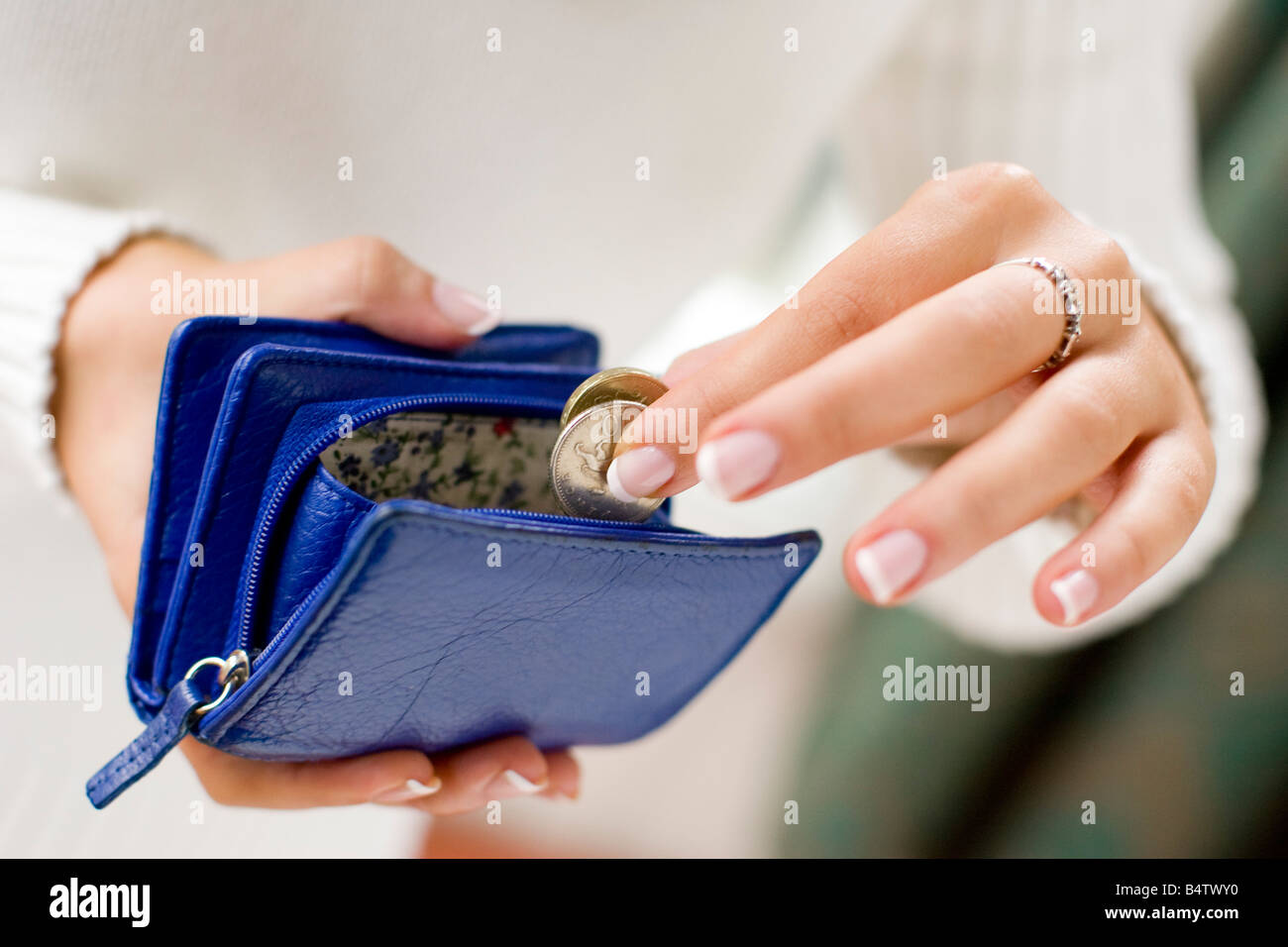young woman putting coins in purse Stock Photo - Alamy