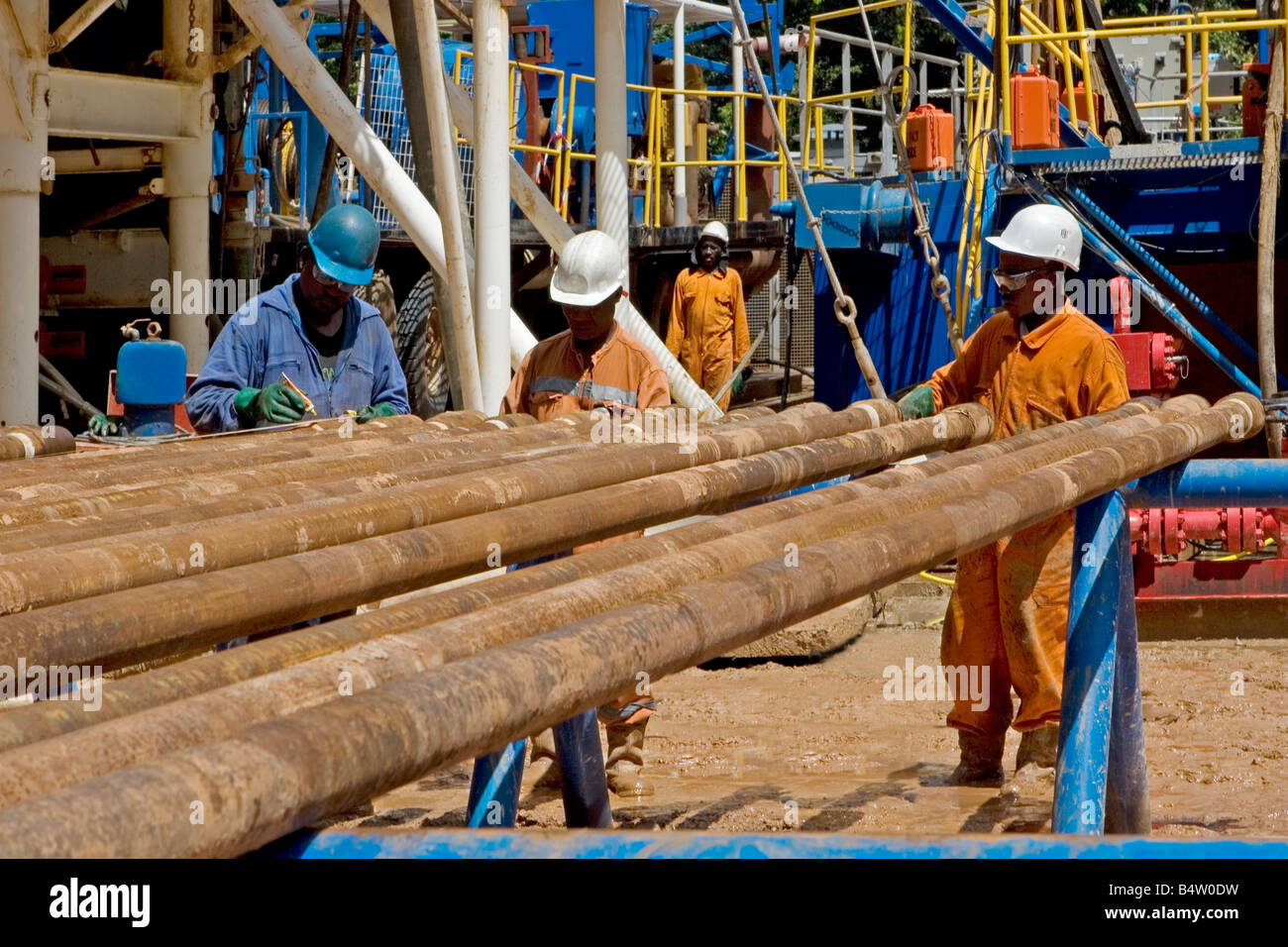 Crewmen at work measuring and preparing pipes before loading onto ...