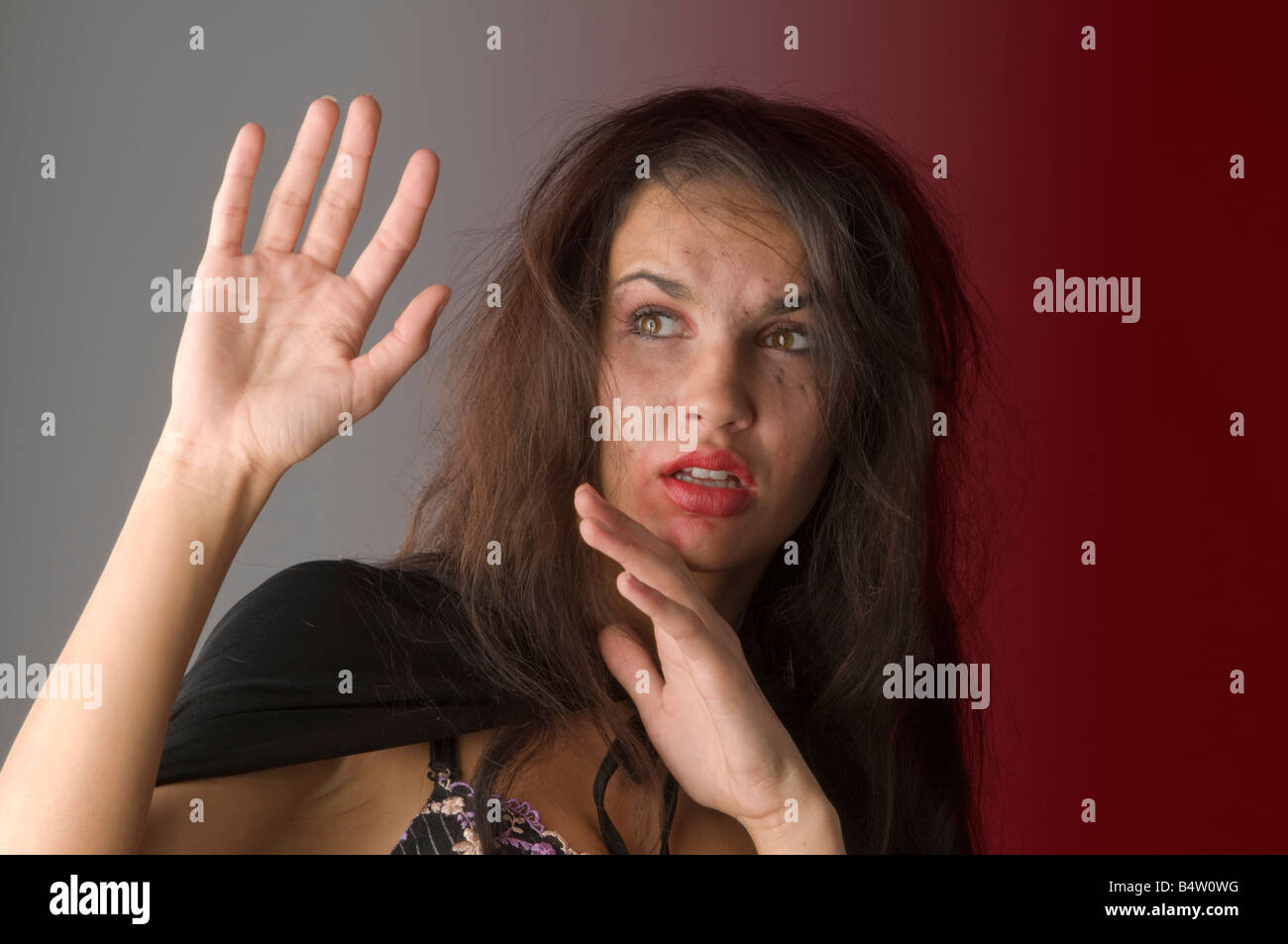 young woman in fear and keeping up hands as to defend from hit Stock ...