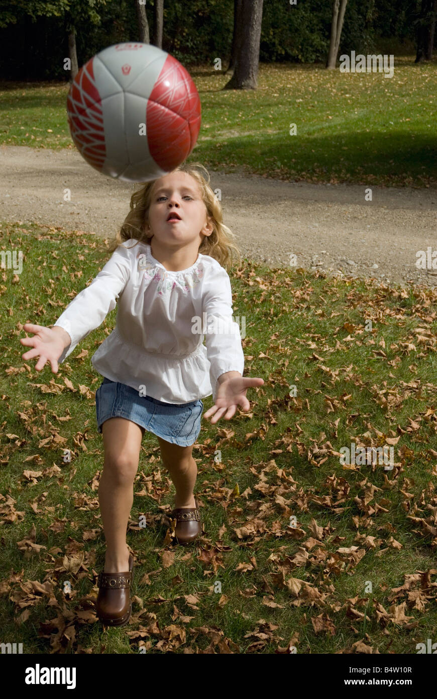 Adorable little girl playing with a large ball Stock Photo - Alamy