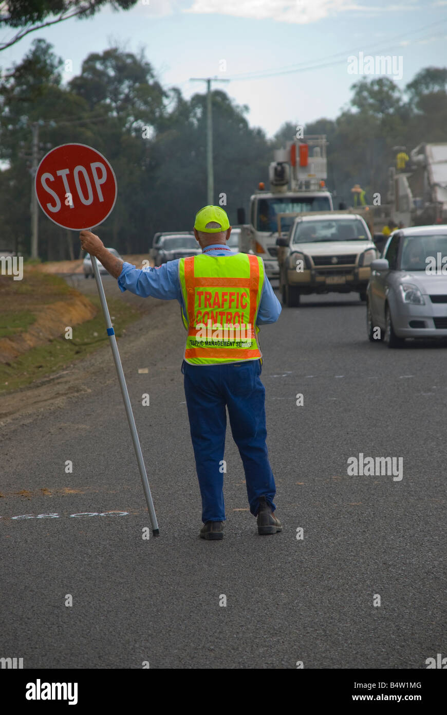 A road worker directing traffic during road maintenance on a highway in ...