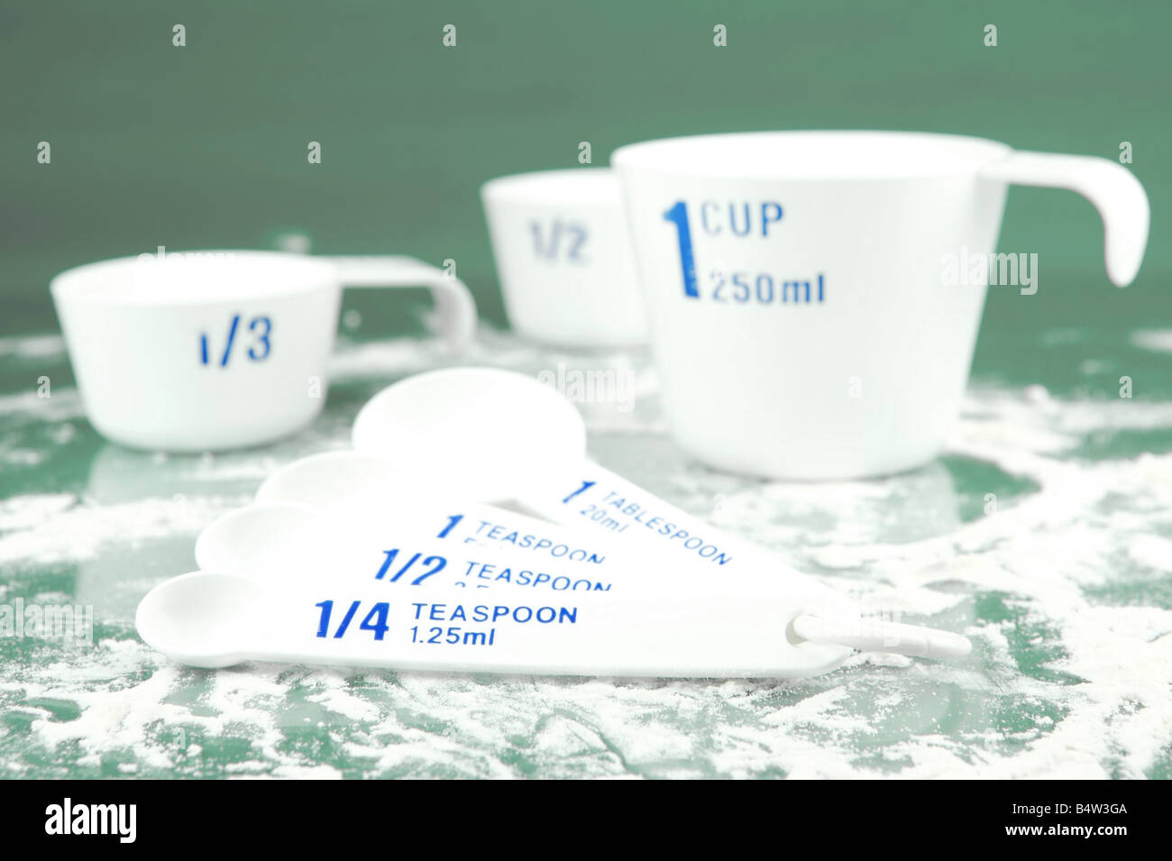 Measuring cups isolated against a green background Stock Photo - Alamy
