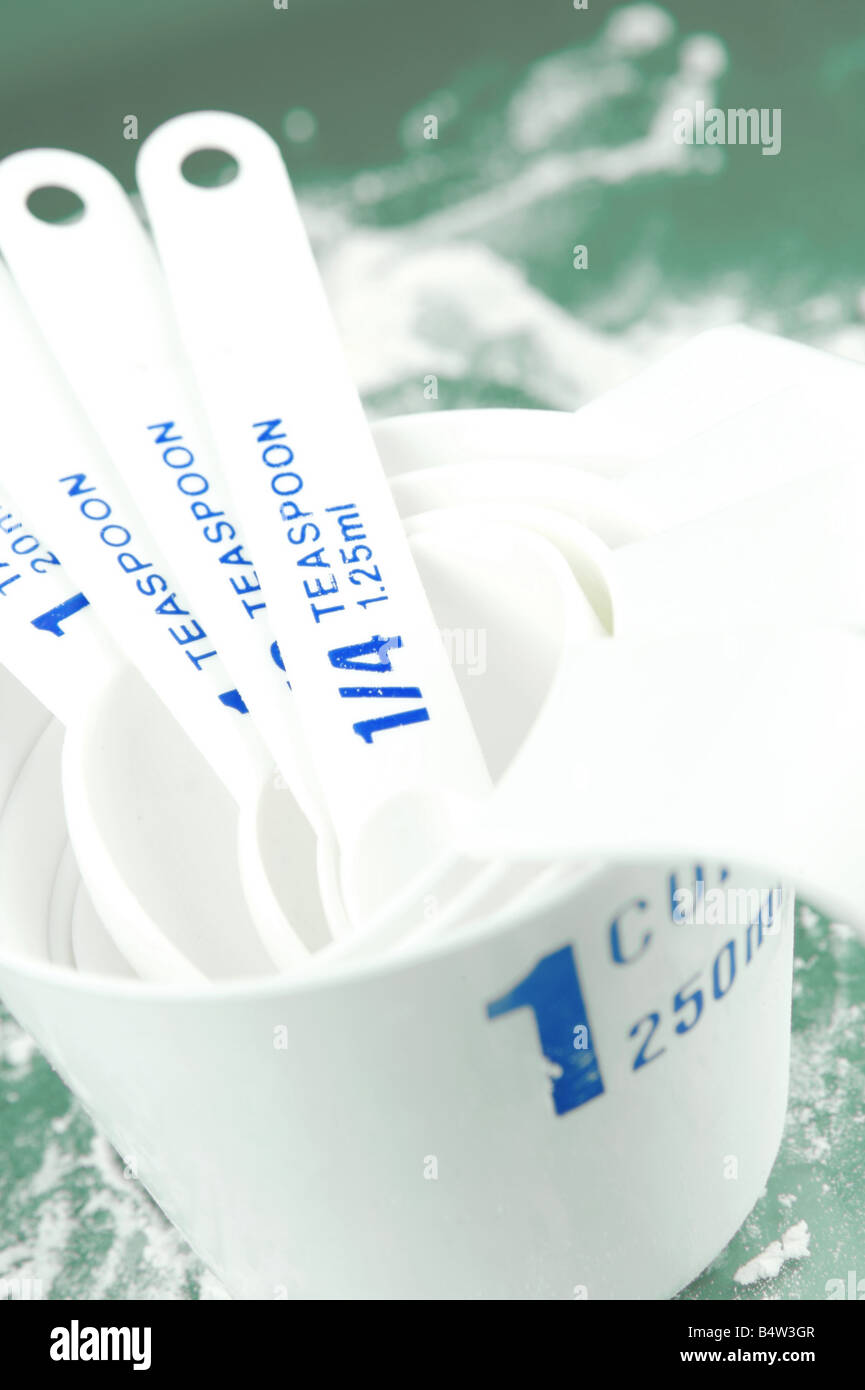 Measuring cups isolated against a green background Stock Photo - Alamy