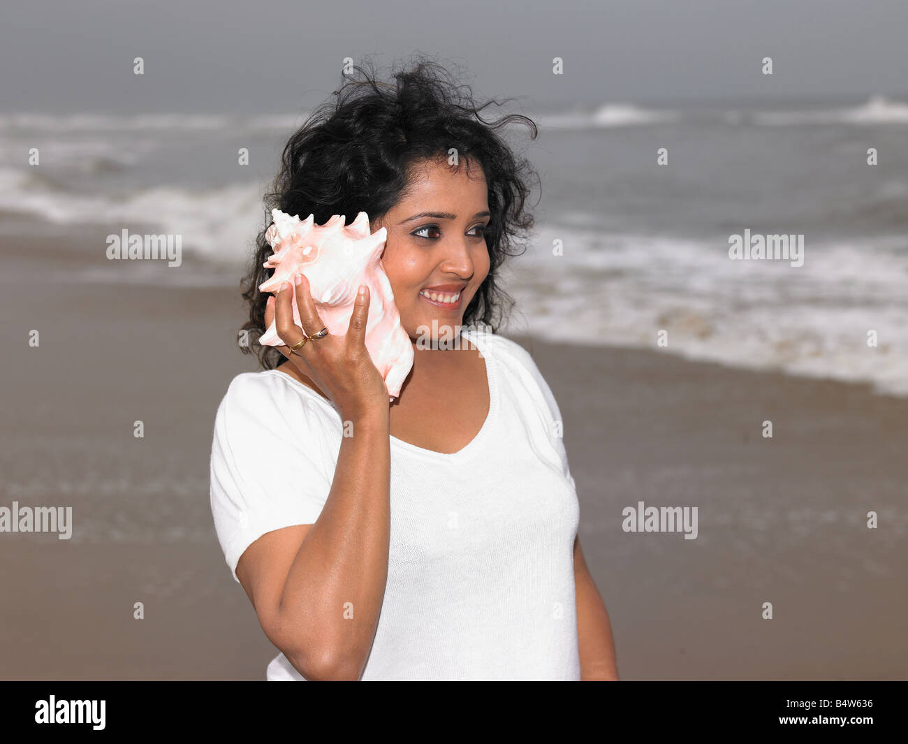 Woman holding conch shell ear hi-res stock photography and images - Alamy
