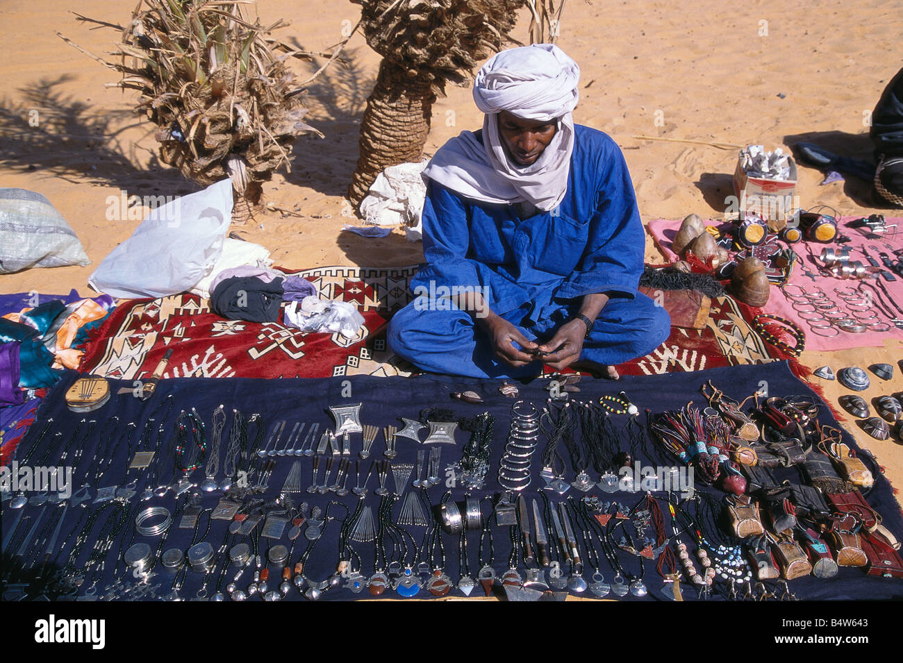 A Taureg sells an assortment of souvenirs to tourists in Fezzan, Sahara ...