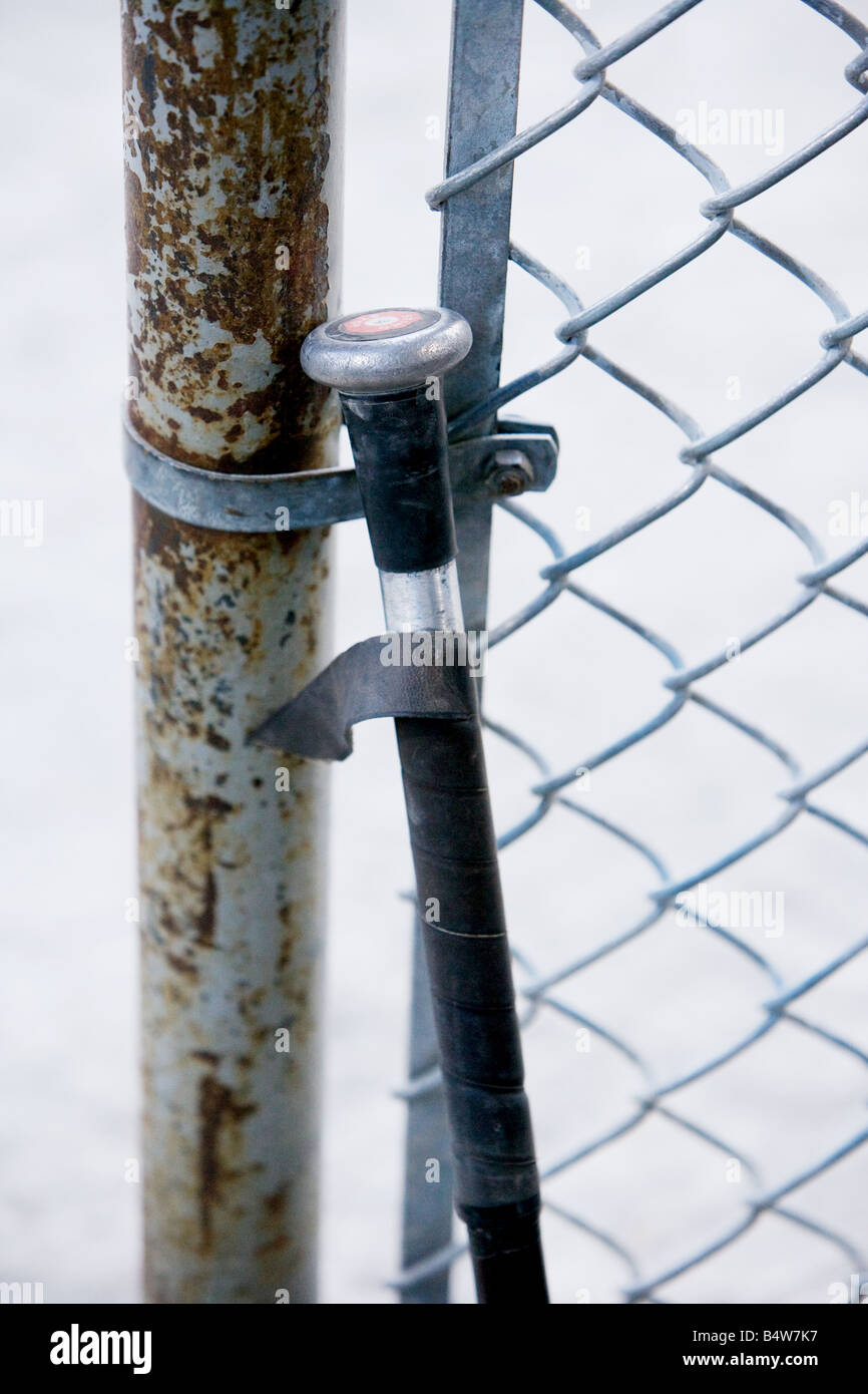 An old softball bat leaning against a chain link fence Stock Photo - Alamy