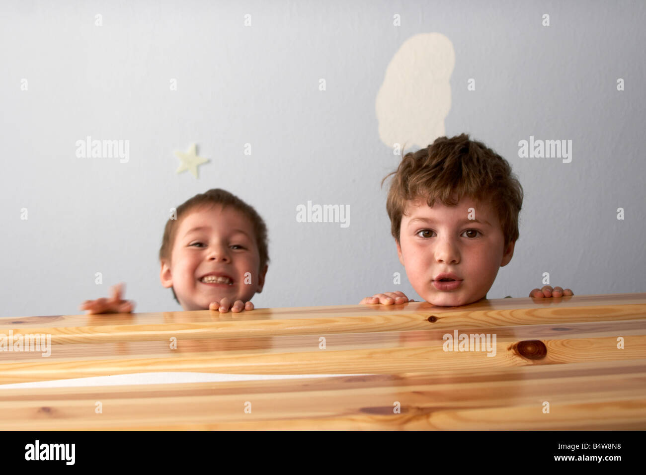 Two young boys children brothers looking over the edge of a bed CJWH ...