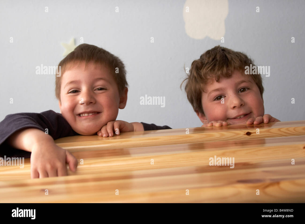 Two young boys children brothers looking over the edge of a bed CJWH ...