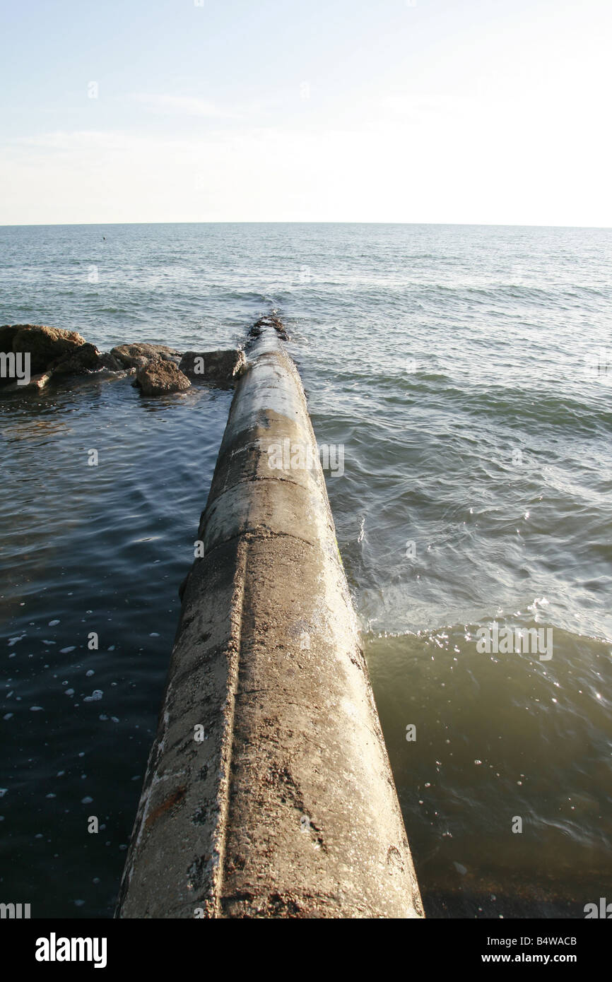 long waste pipe going into the sea Stock Photo - Alamy