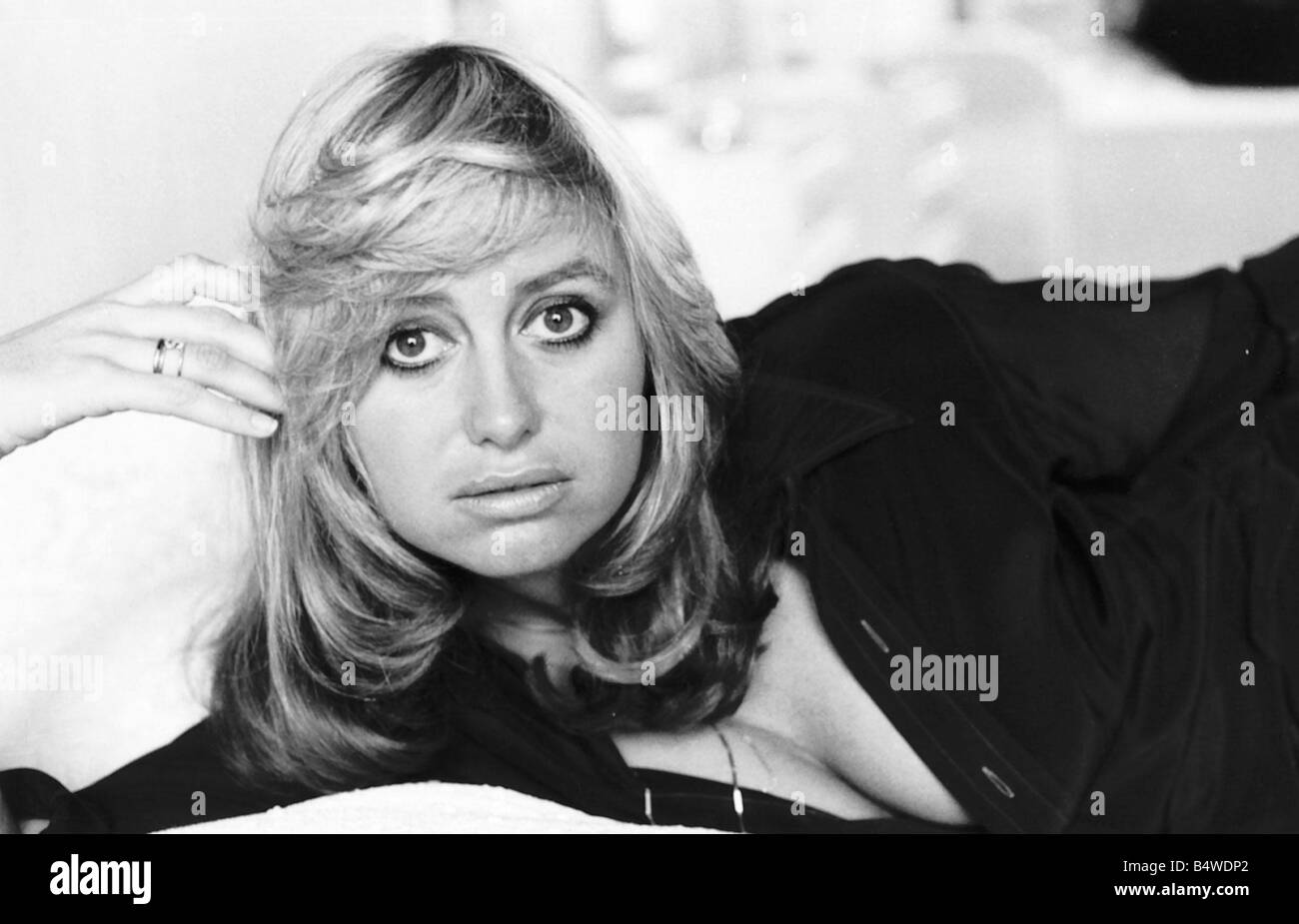 Susan George actress lying on a bed on her side holding her head up ...