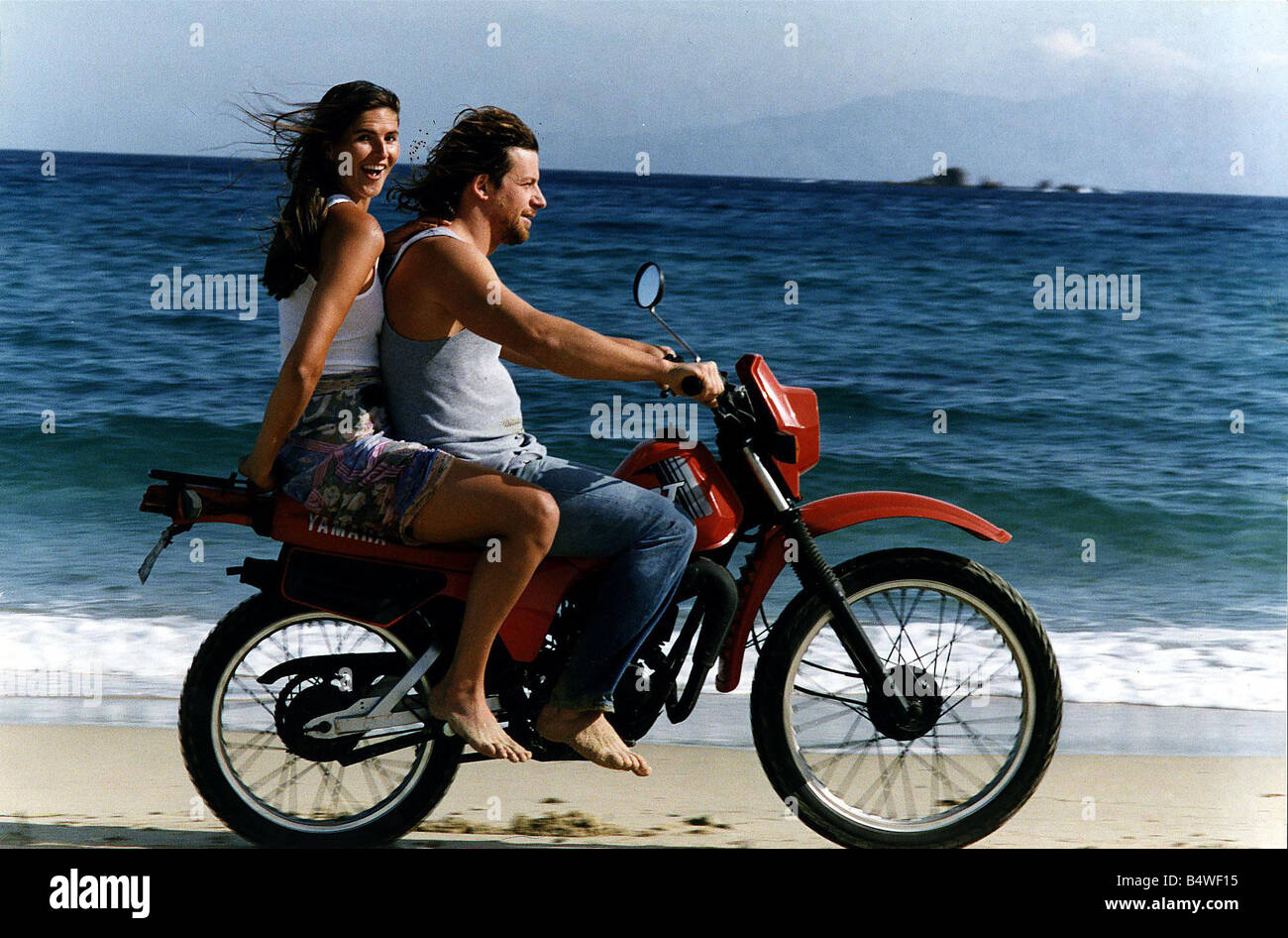 Lynn Wales with Andreas taverna owner on back of motorbike on beach ...