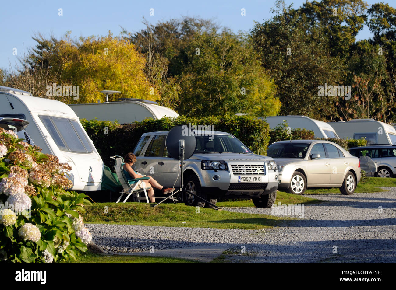 Caravan site in South Devon England UK Woman sitting and reading a book ...