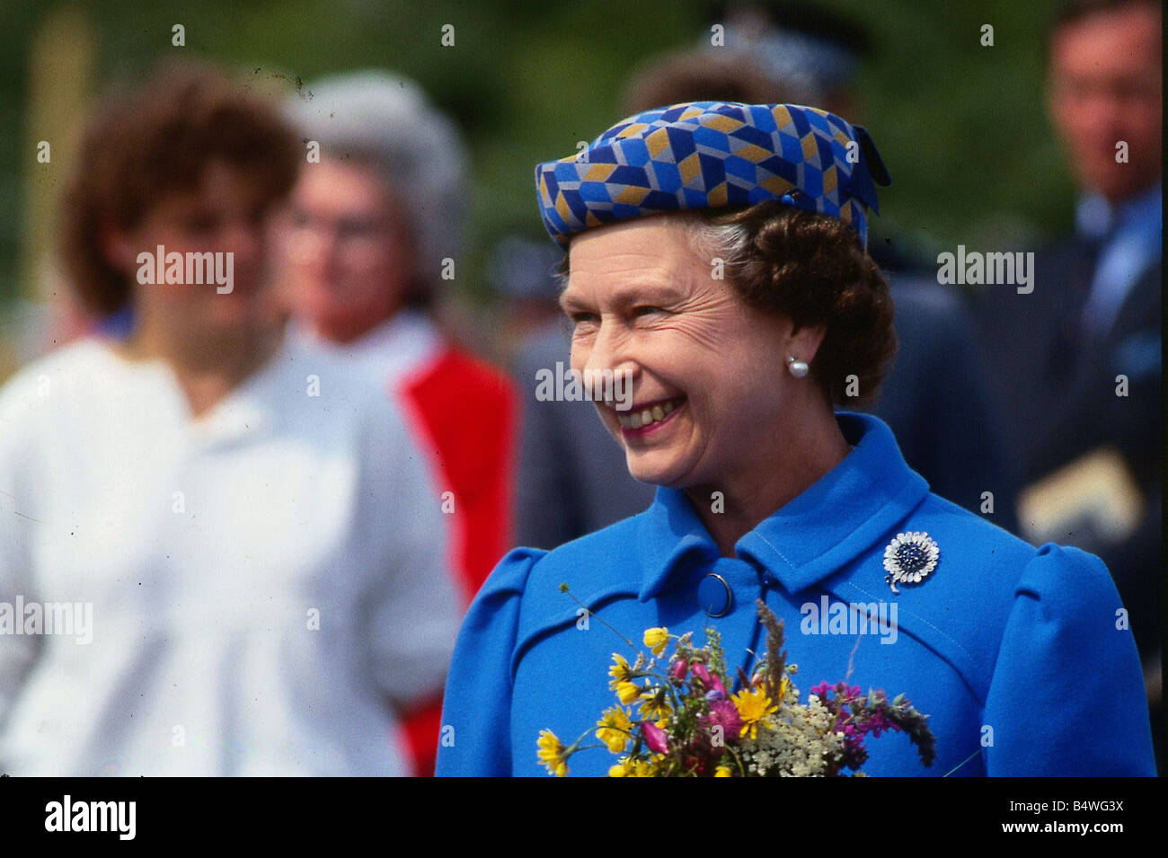 Queen Elizabeth II August 1986 holding flowers wearing a blue coat ...