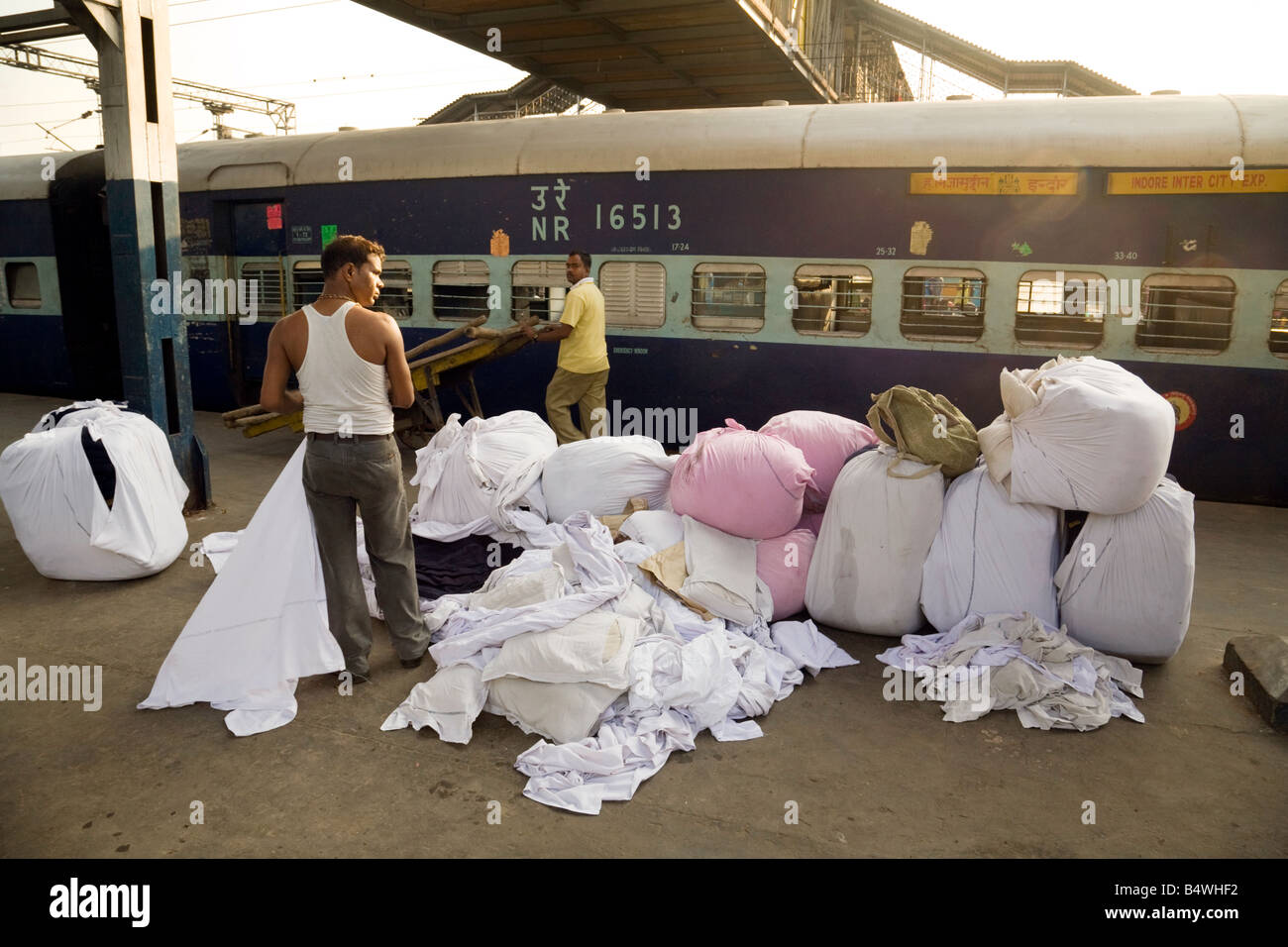 Rail workers load clean linen for the sleeper trains, New delhi station ...