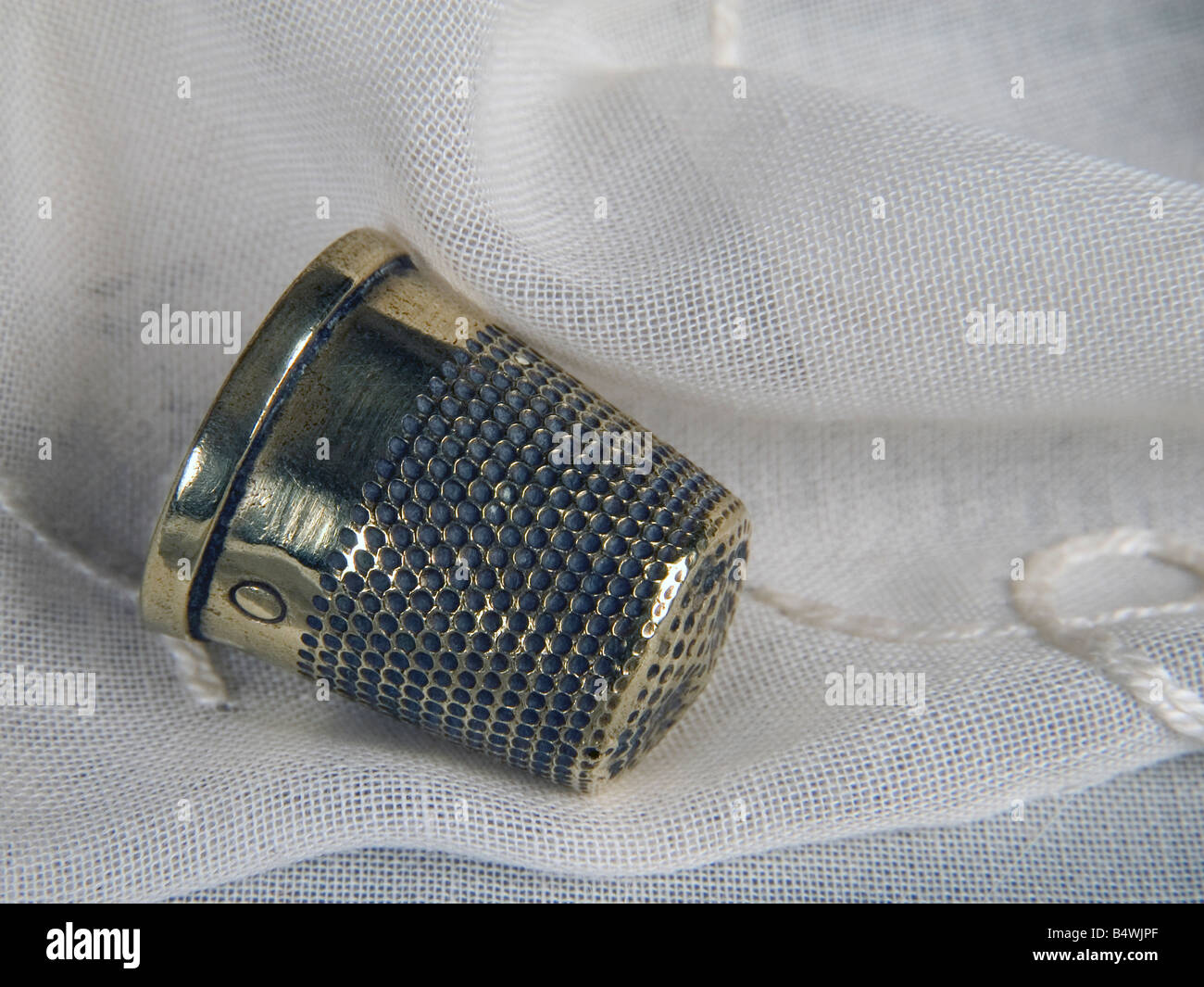 Brass thimble on white cotton fabric Stock Photo - Alamy