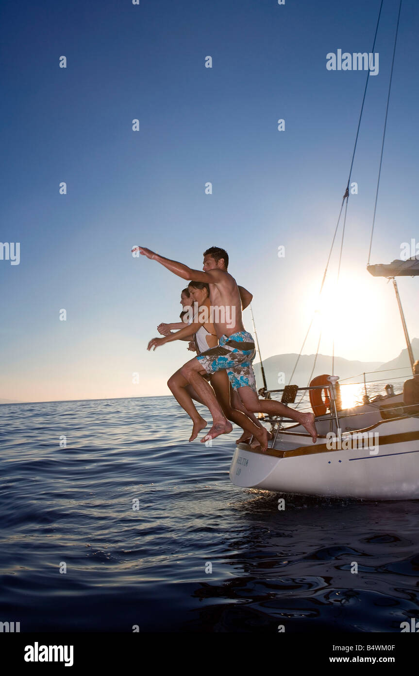 Young people jumping from sail boat Stock Photo - Alamy