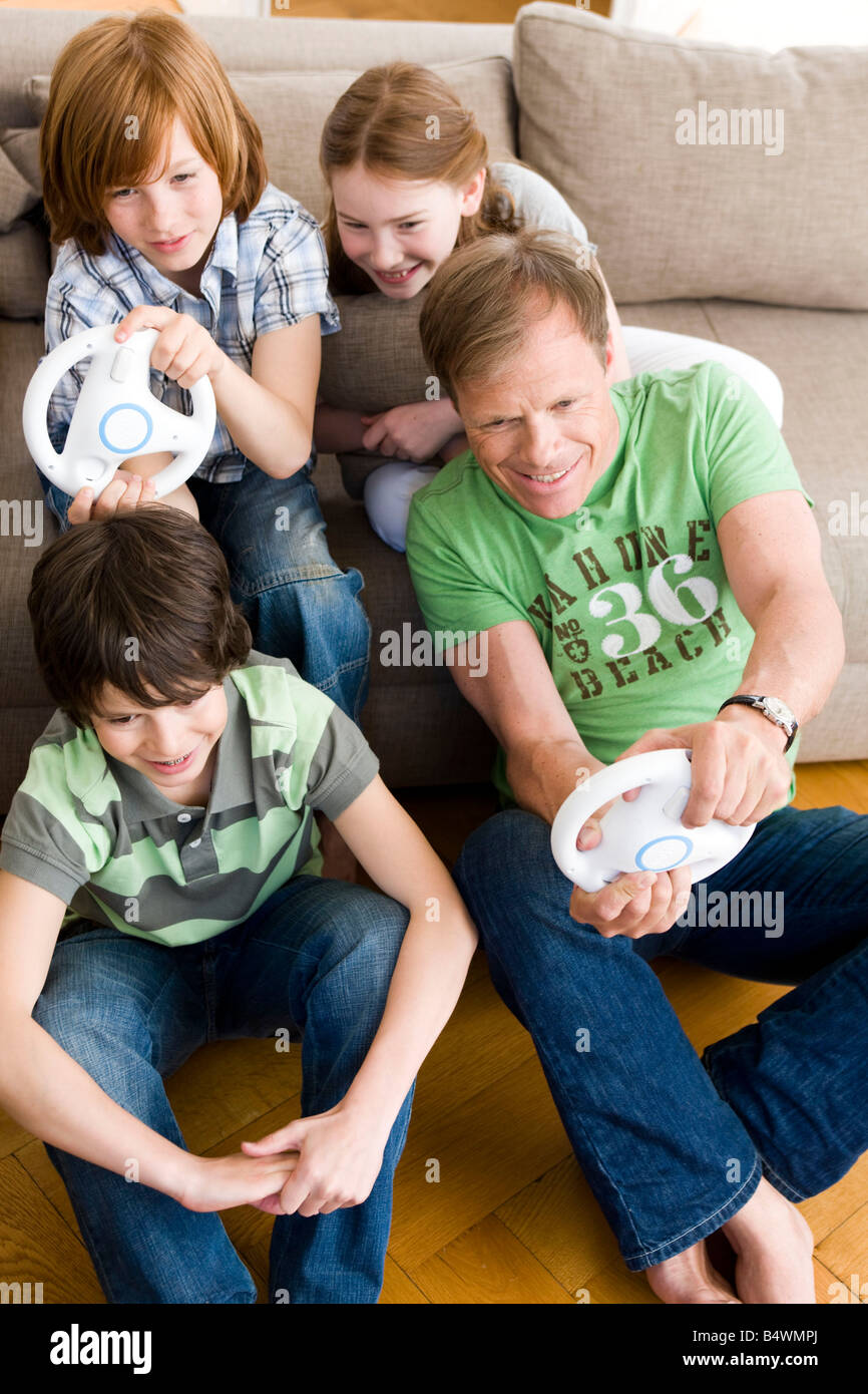 Family playing video games with wheel Stock Photo - Alamy