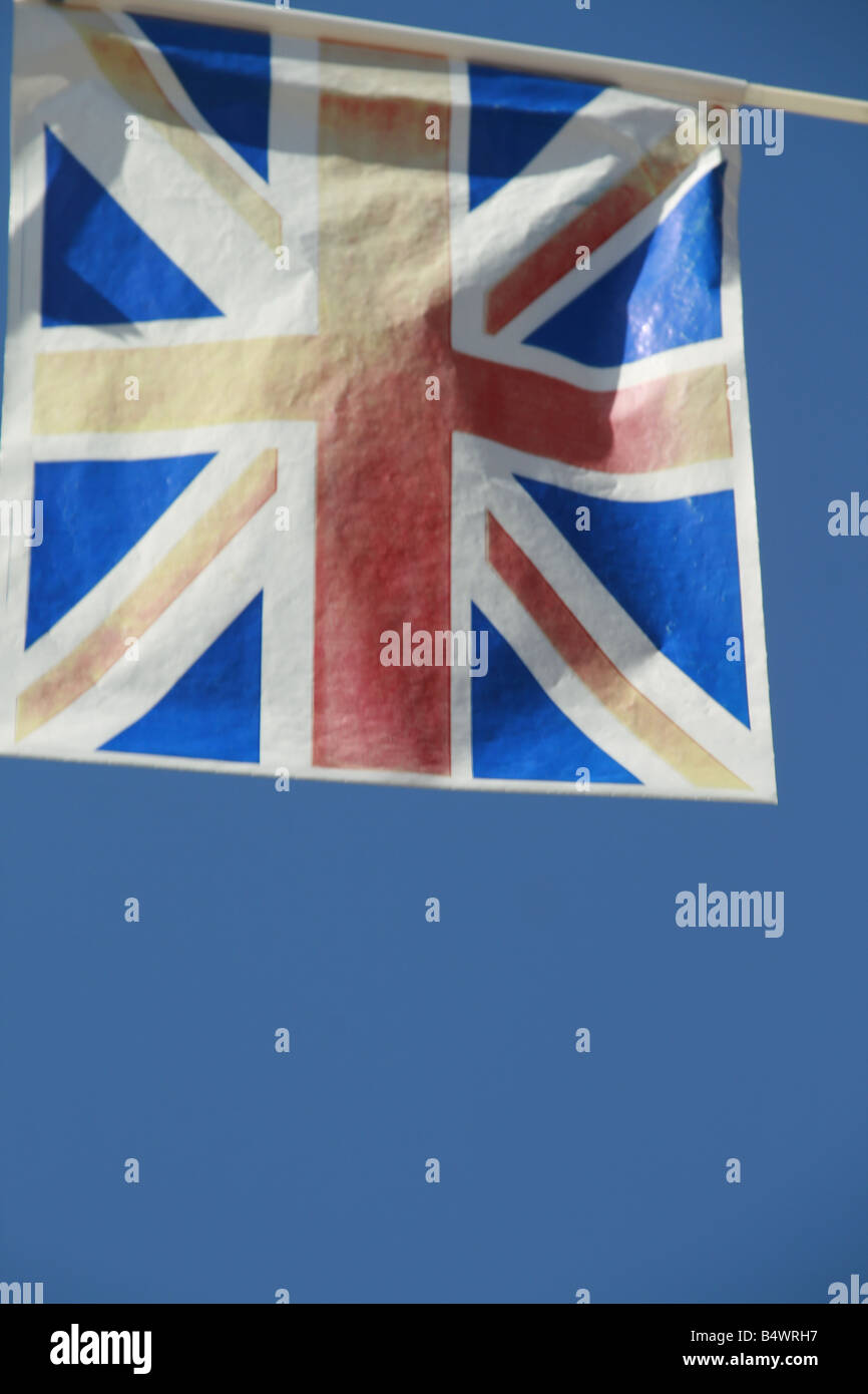old faded union jack flag flying in wind in sun Stock Photo - Alamy