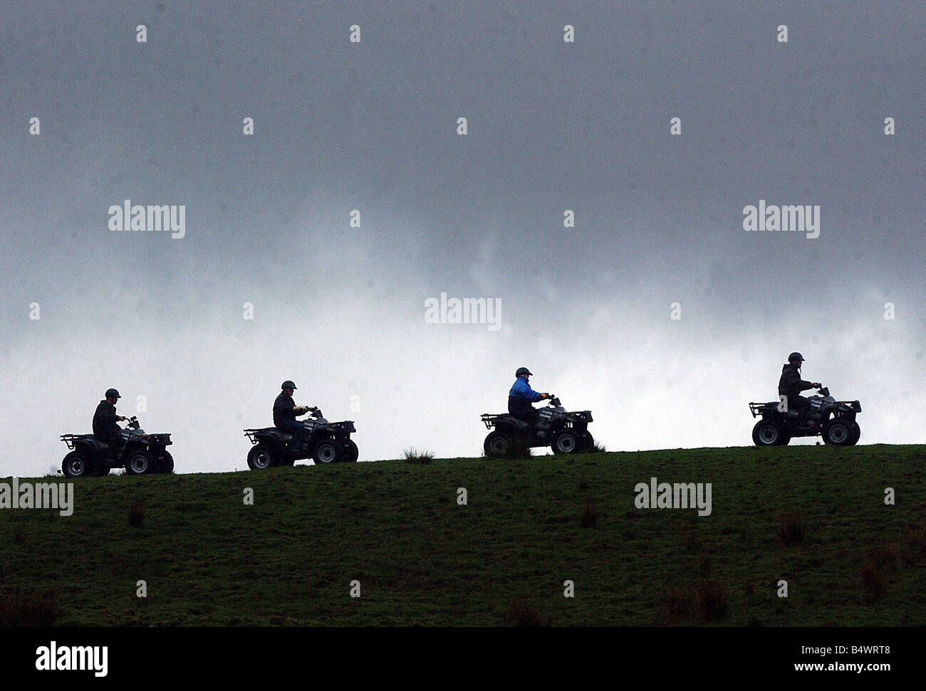 Riders follow each other up hill on their quad bikes Stock Photo - Alamy