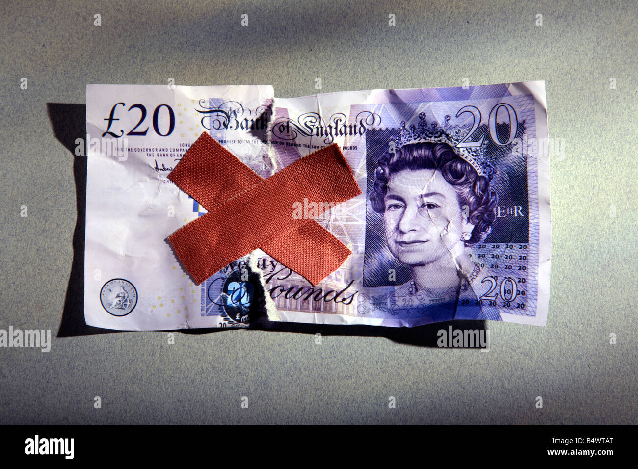 Torn £20 British bank note with plasters Stock Photo - Alamy