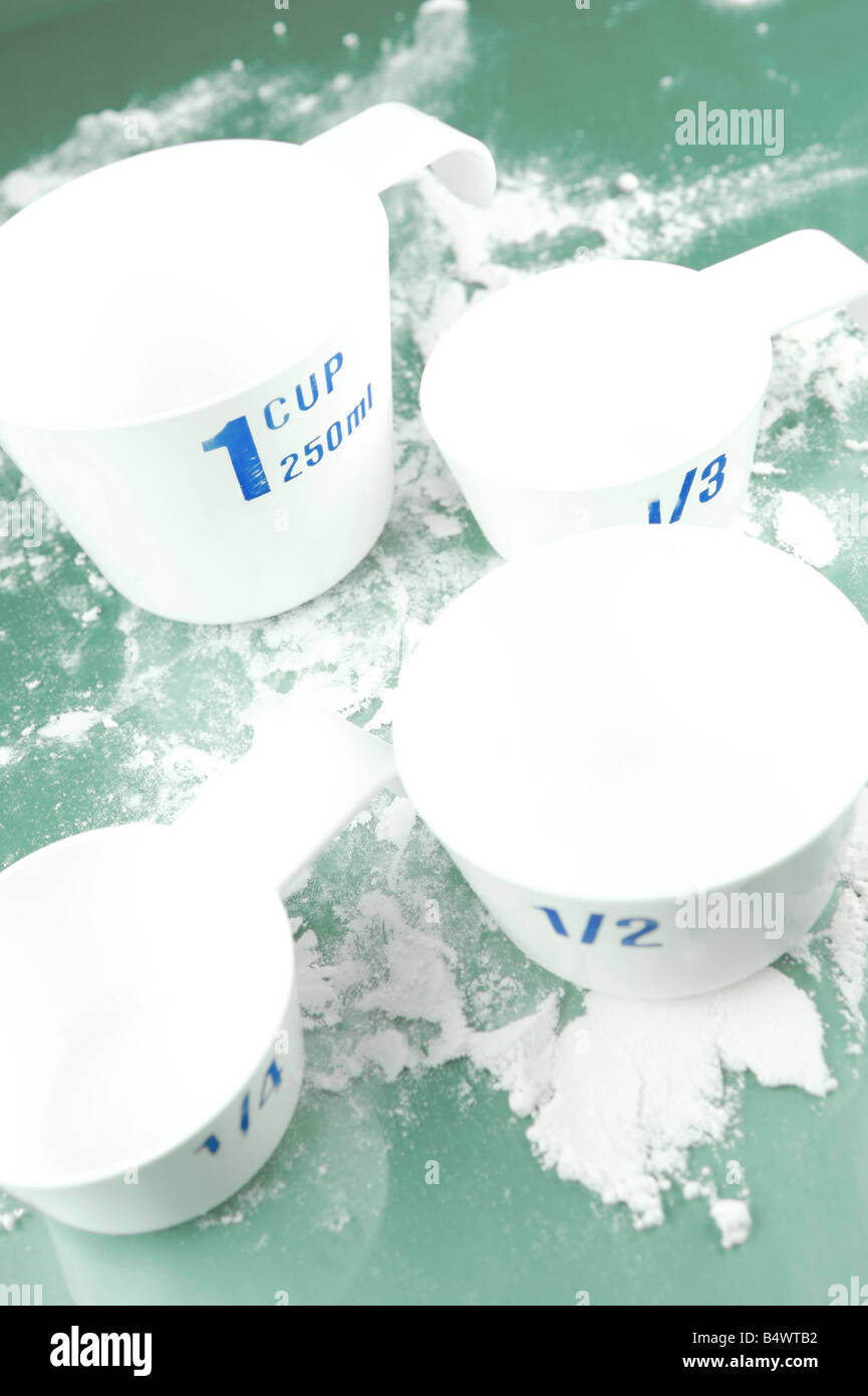 Measuring cups isolated against a green background Stock Photo - Alamy