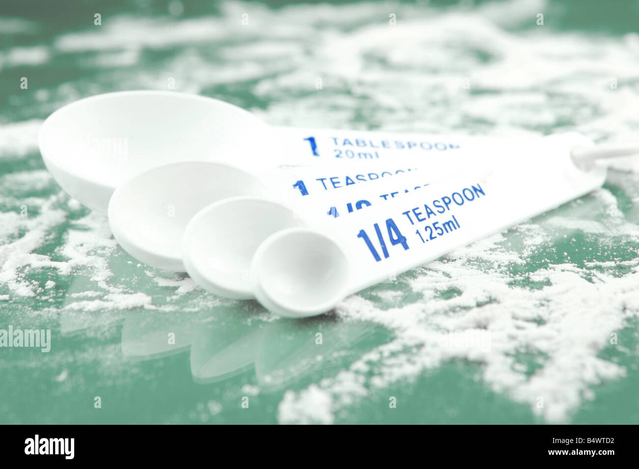 Measuring cups isolated against a green background Stock Photo - Alamy