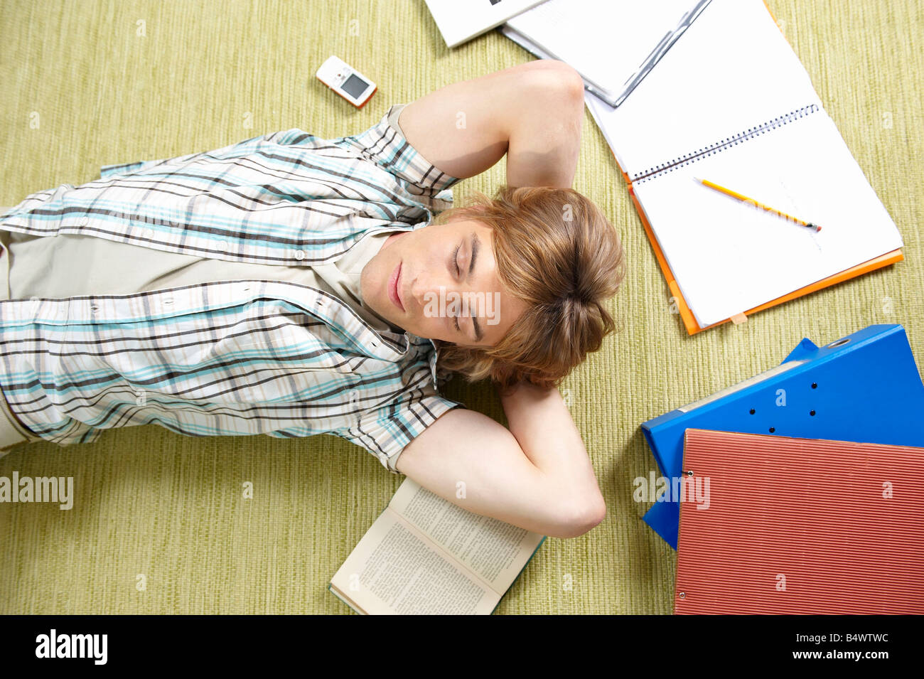 Young man lying on rug Stock Photo - Alamy