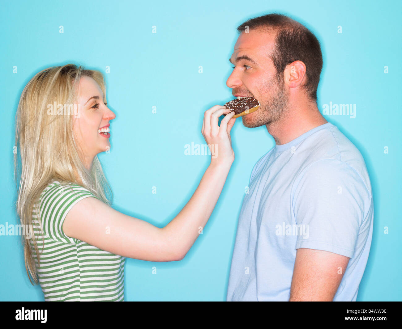 Young woman feeding man with cake Stock Photo - Alamy