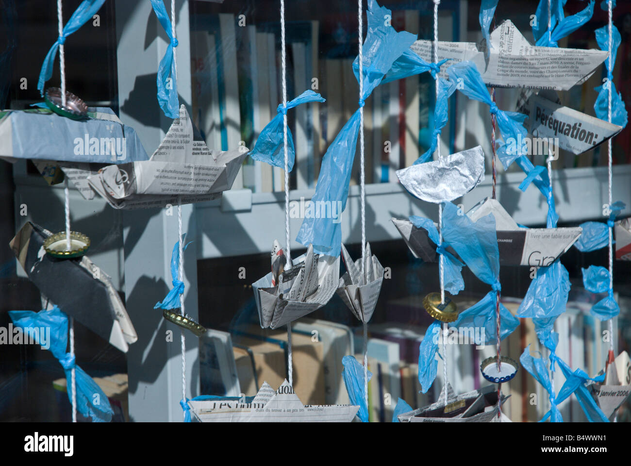 Paper boats and bottle caps used to make a mobil from recycled ...