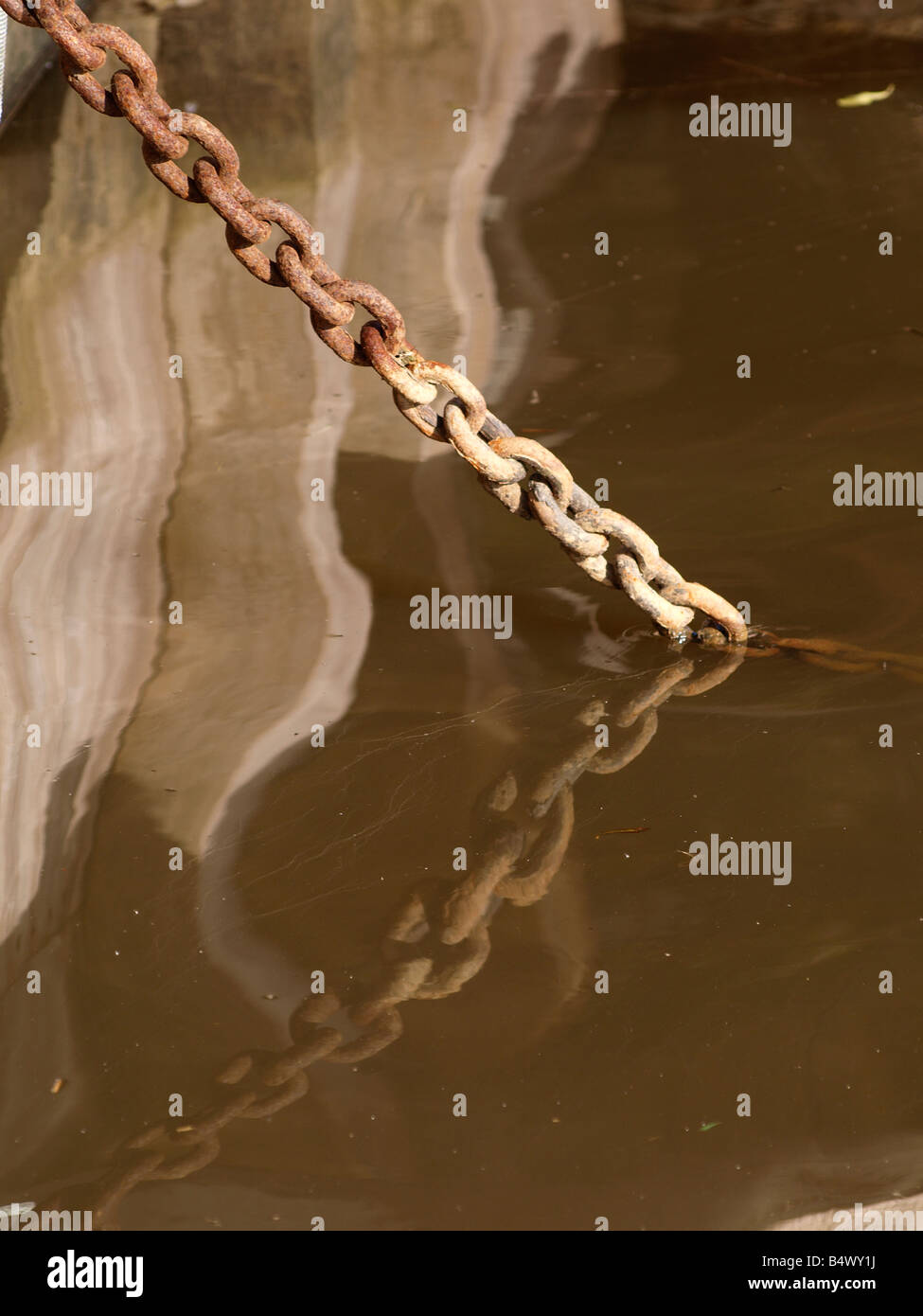 Old rusty chain going into water and its reflection Stock Photo - Alamy