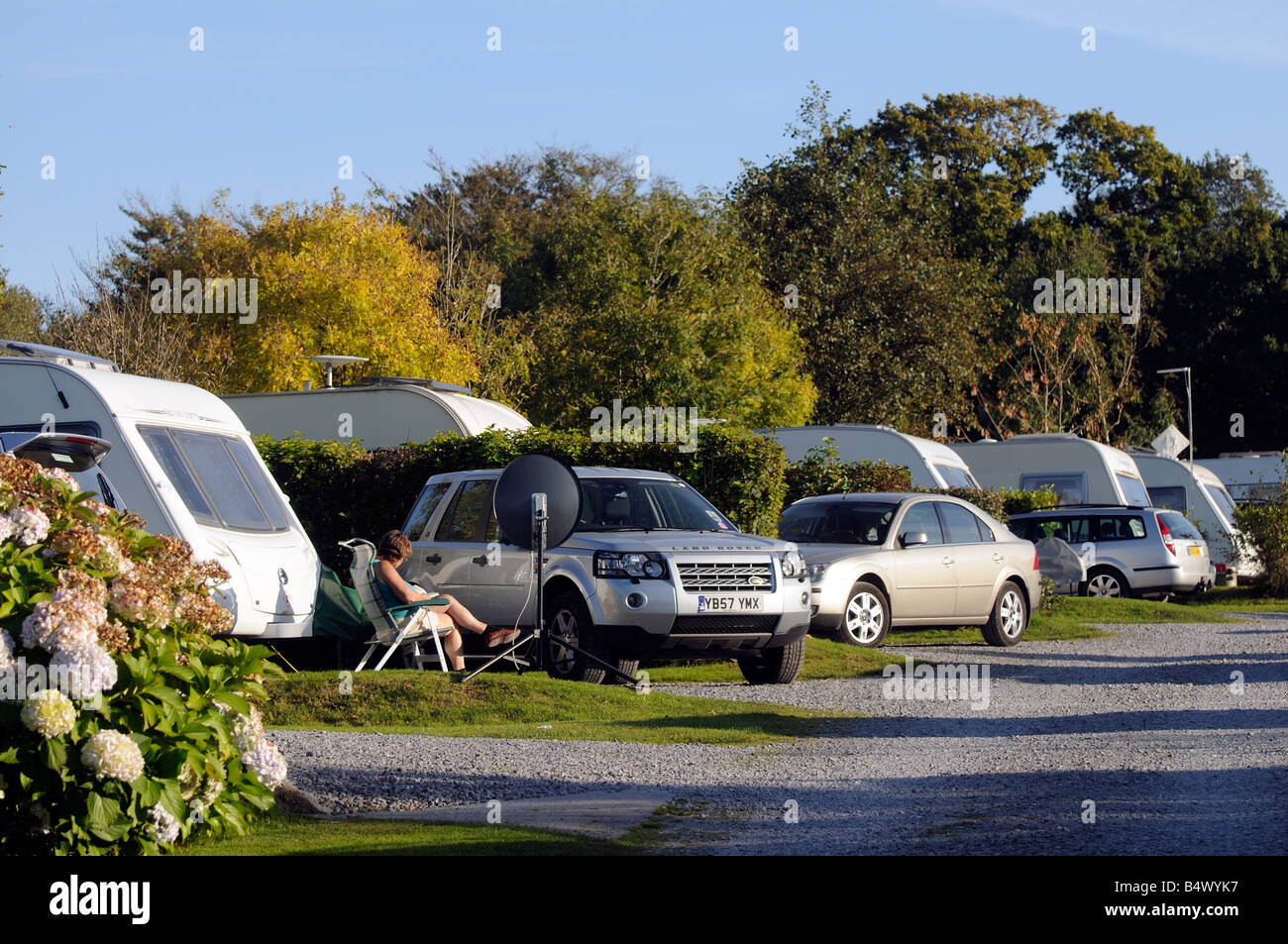Caravan site in South Devon England UK Woman sitting and reading a book ...