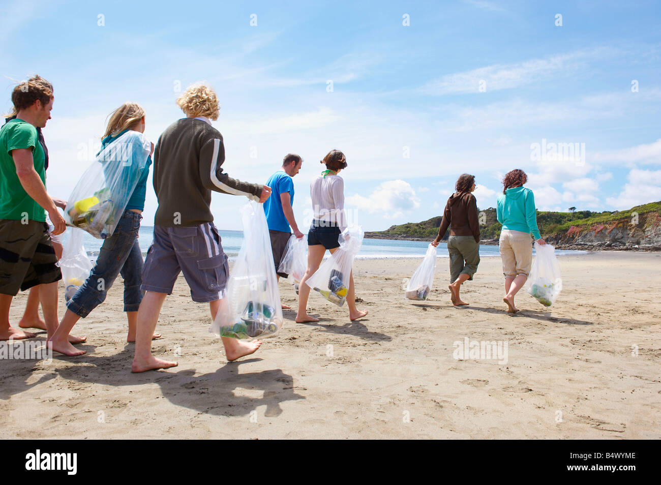 Young people collecting garbage on beach Stock Photo - Alamy