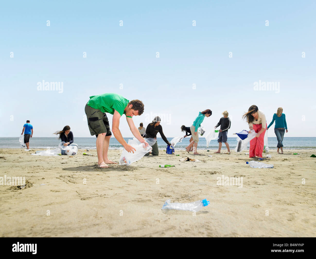 Young people collecting garbage on beach Stock Photo - Alamy