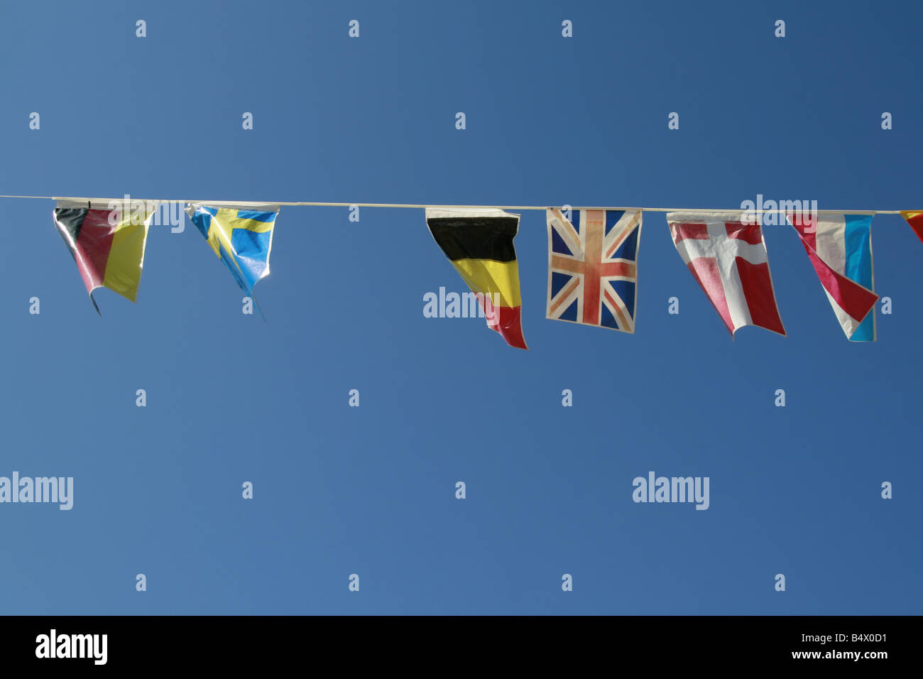 old faded international flags flying in wind in sun Stock Photo - Alamy