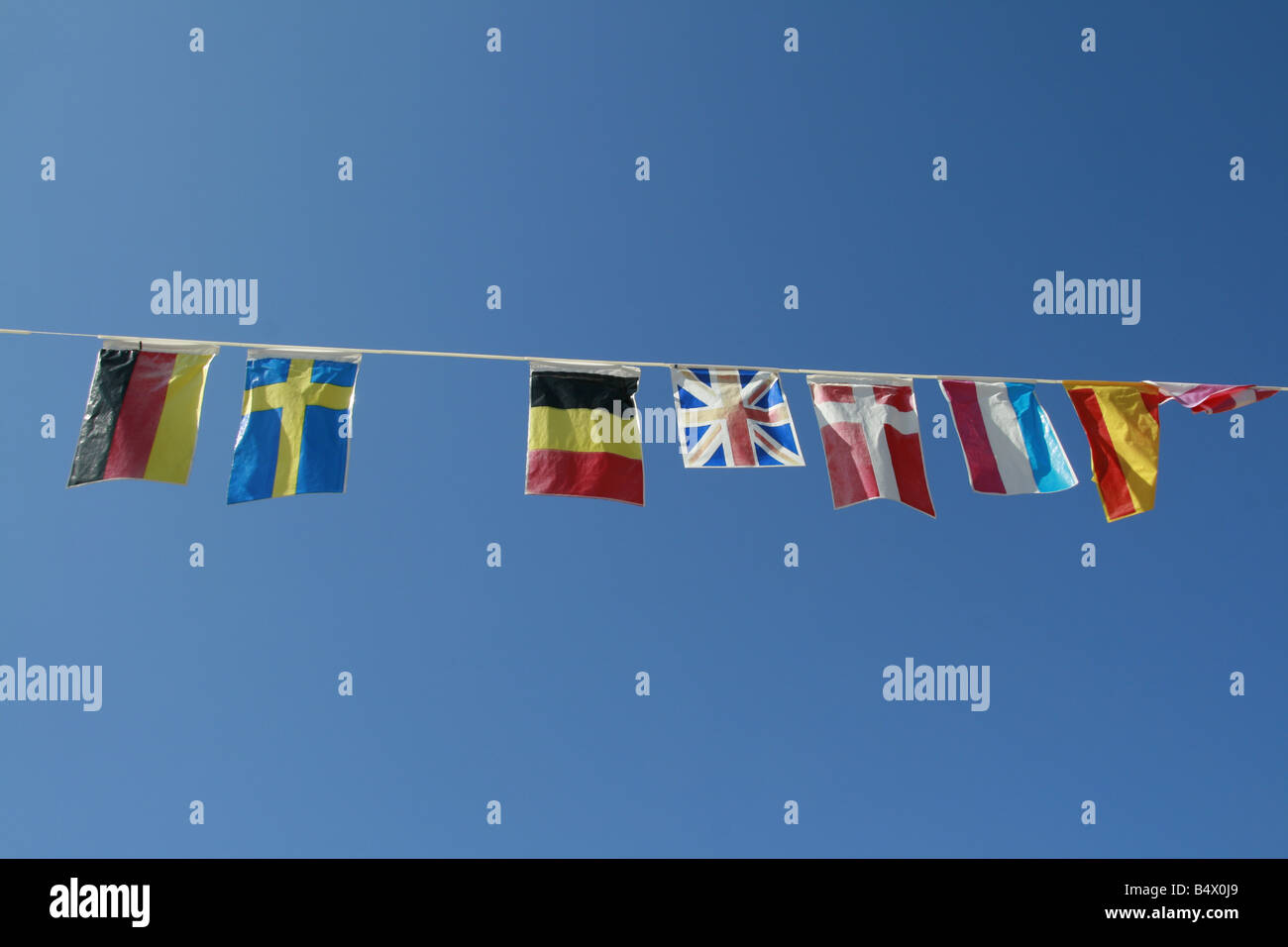 old faded international flags flying in wind in sun Stock Photo - Alamy