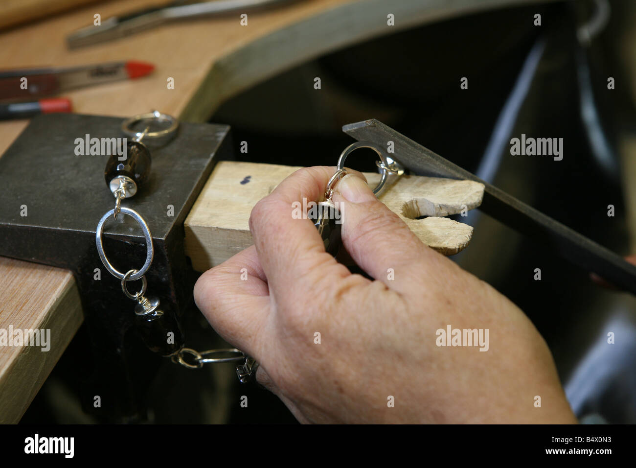 a female silversmith working on some jewelry rings and stuff in her ...