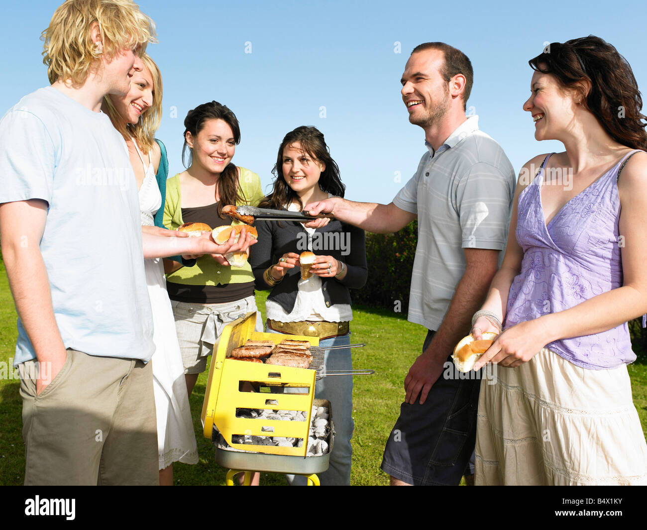 Group of people around barbecue Stock Photo - Alamy