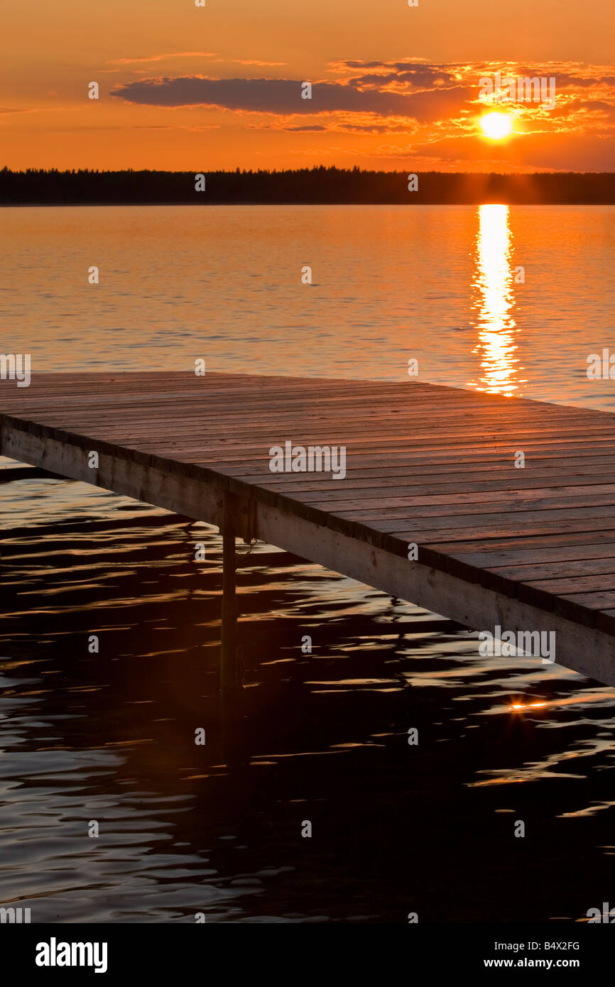 Sunset over a wooden wharf on Lake Audy, Riding Mountain National Park ...
