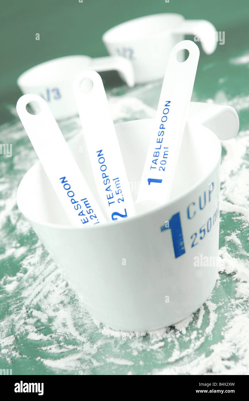 Measuring cups isolated against a green background Stock Photo - Alamy