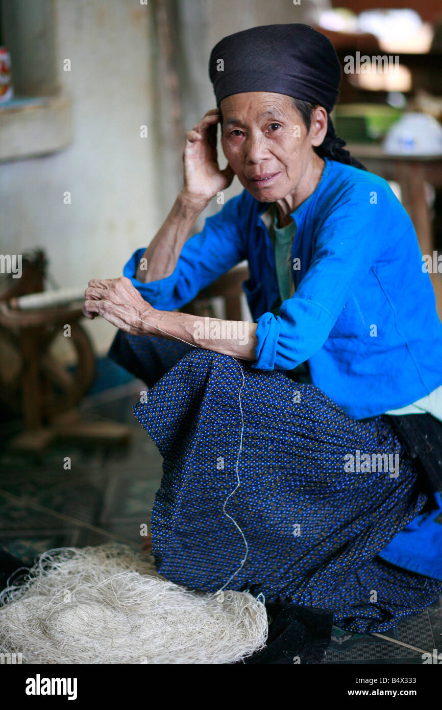 White Hmong woman spinning flax at a village in Ha Giang Province ...