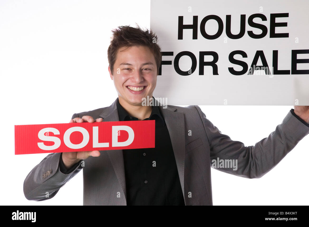 Real estate agent holding a House For Sale and Sold signs Stock Photo ...