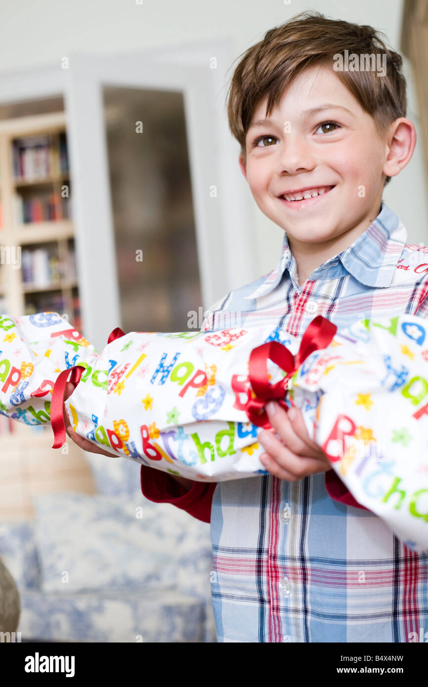 Young boy standing with birthday-present Stock Photo - Alamy