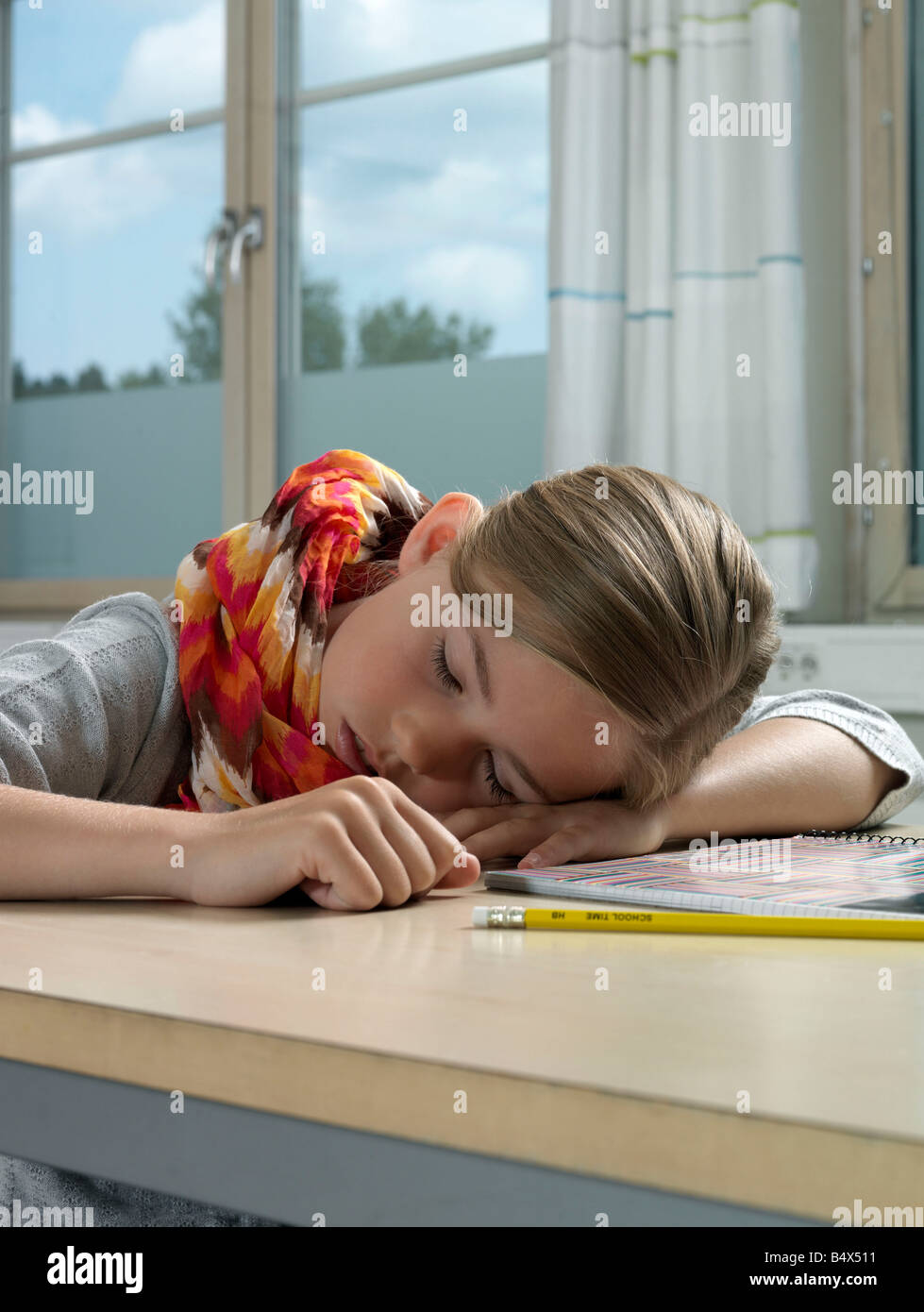 Girl resting on school table Stock Photo - Alamy