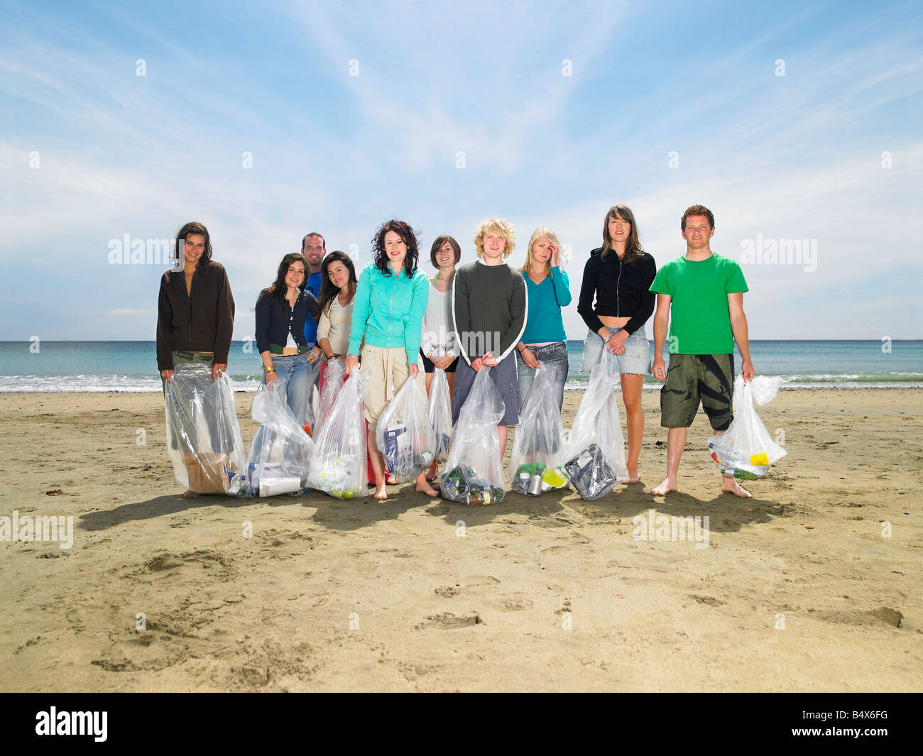 Young people collecting garbage on beach Stock Photo - Alamy