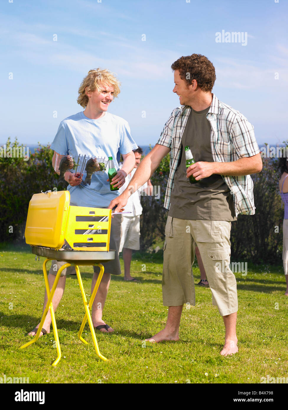 Young men chatting by barbecue Stock Photo - Alamy