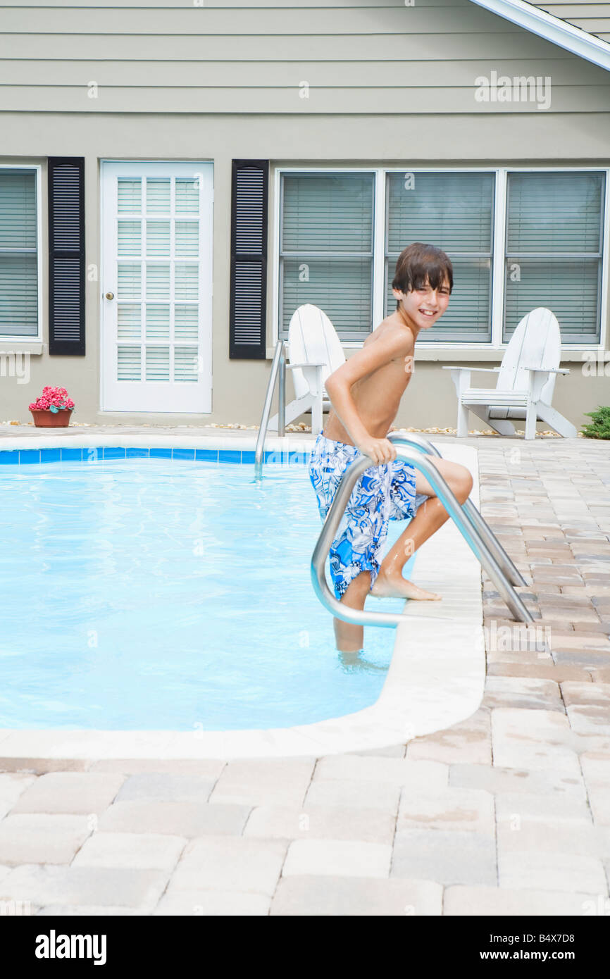 Boy stepping out of swimming pool Stock Photo - Alamy