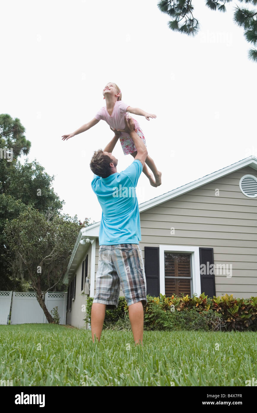 Father lifting daughter in backyard Stock Photo - Alamy