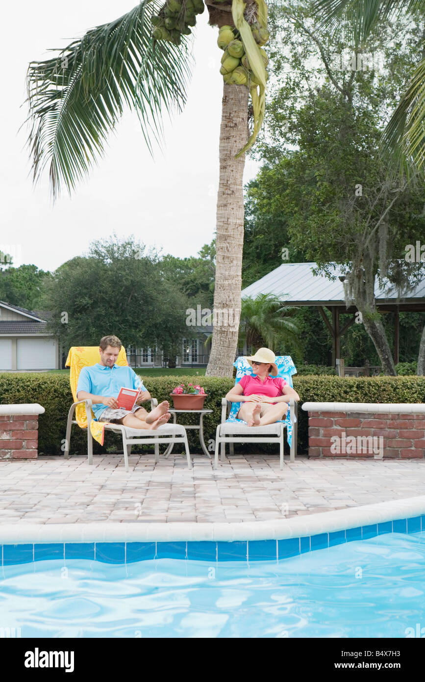 Couple relaxing poolside Stock Photo - Alamy