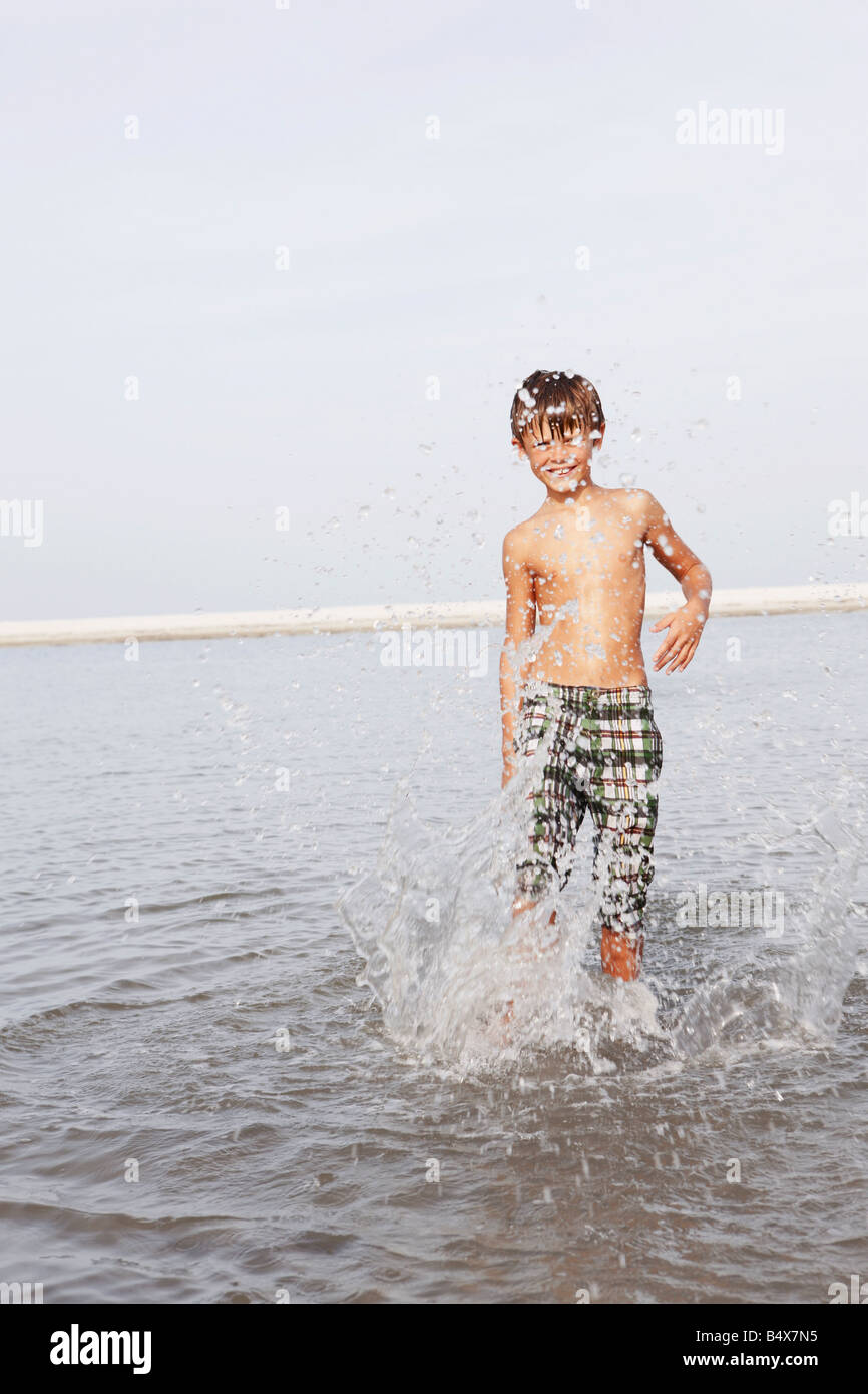 Boy splashing in ocean Stock Photo - Alamy